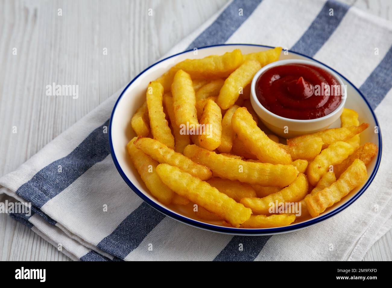 Homemade Unhealthy Crinkle French Fries with Ketchup on a Plate, low ...