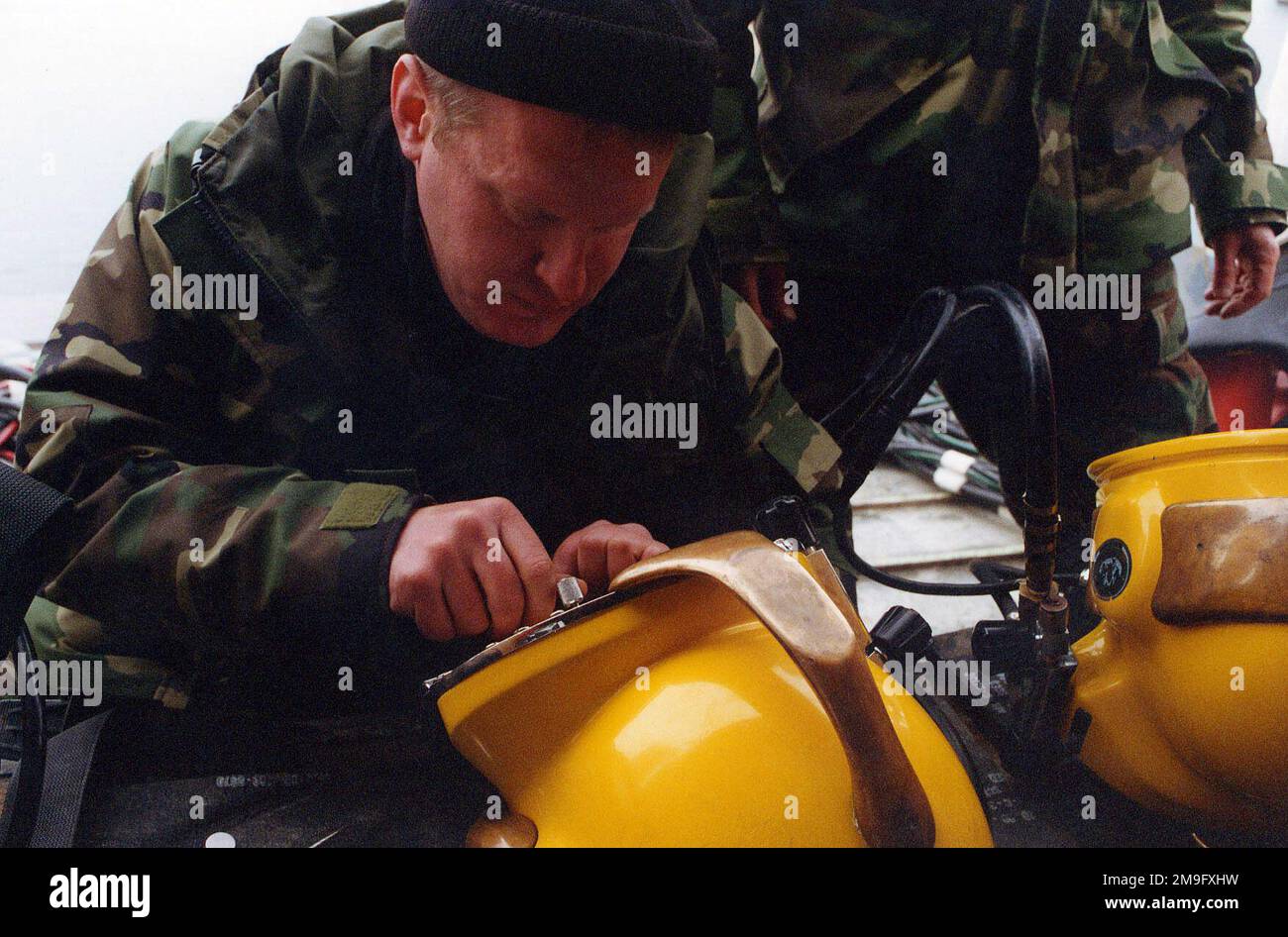 Performing helmet inspections prior to a salvage dive, PETTY Officer ...