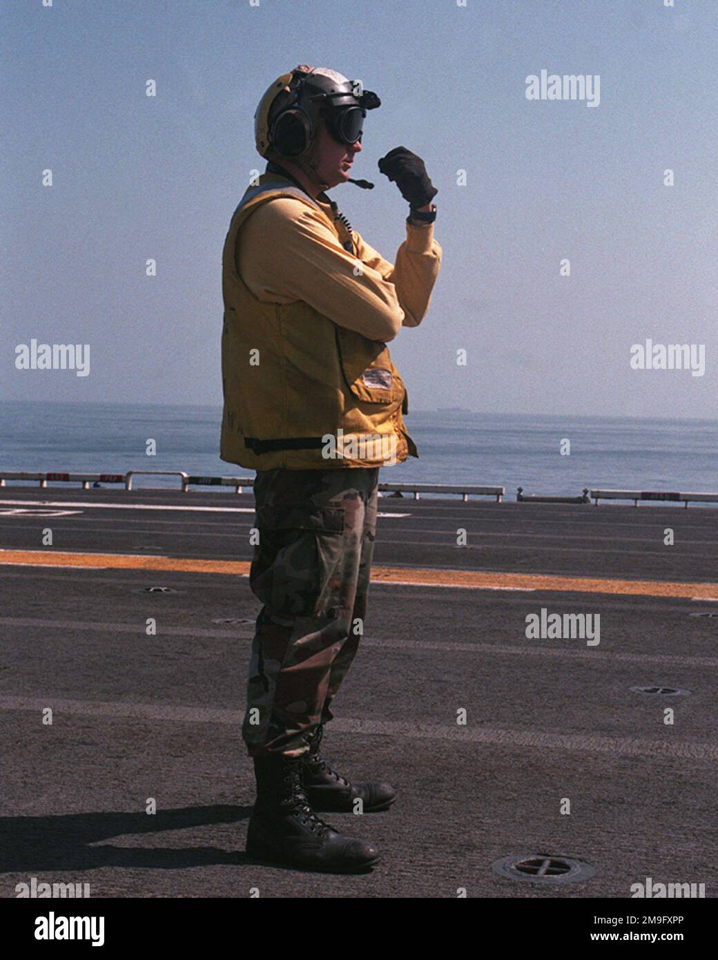 A US Navy Sailor stationed aboard the USS TARAWA (LHA 1) directs the ...