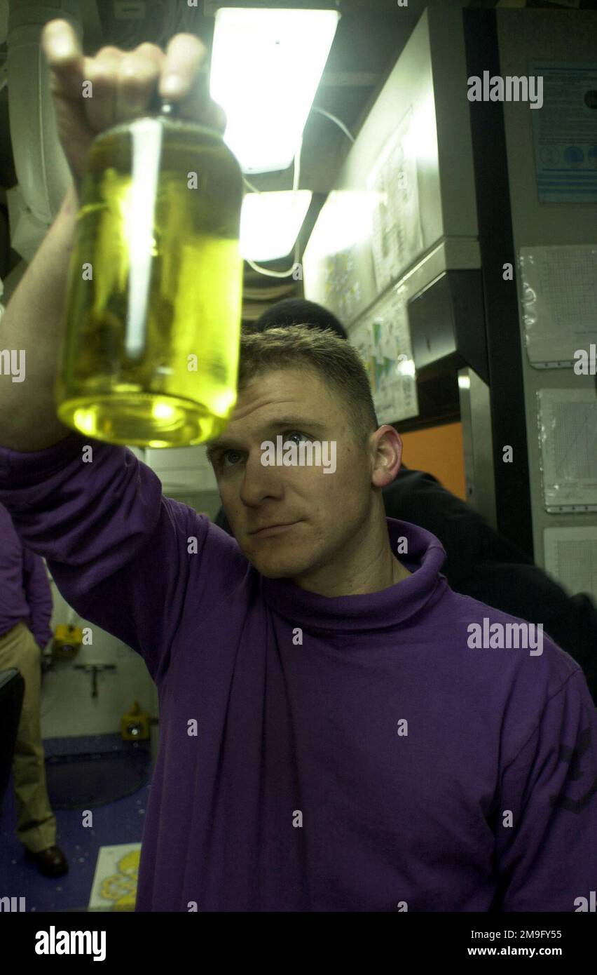 Aviation Boatswain's Mate 3rd Class Bradley Shoaf checks for impurities ...