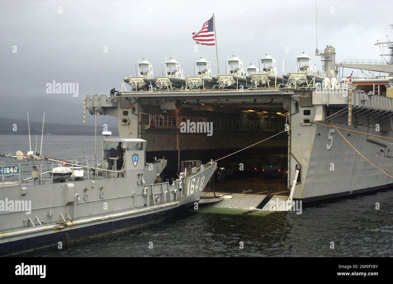 A landing craft unit unloads cargo from the USS OGDEN (LPD 5), a 570 ...