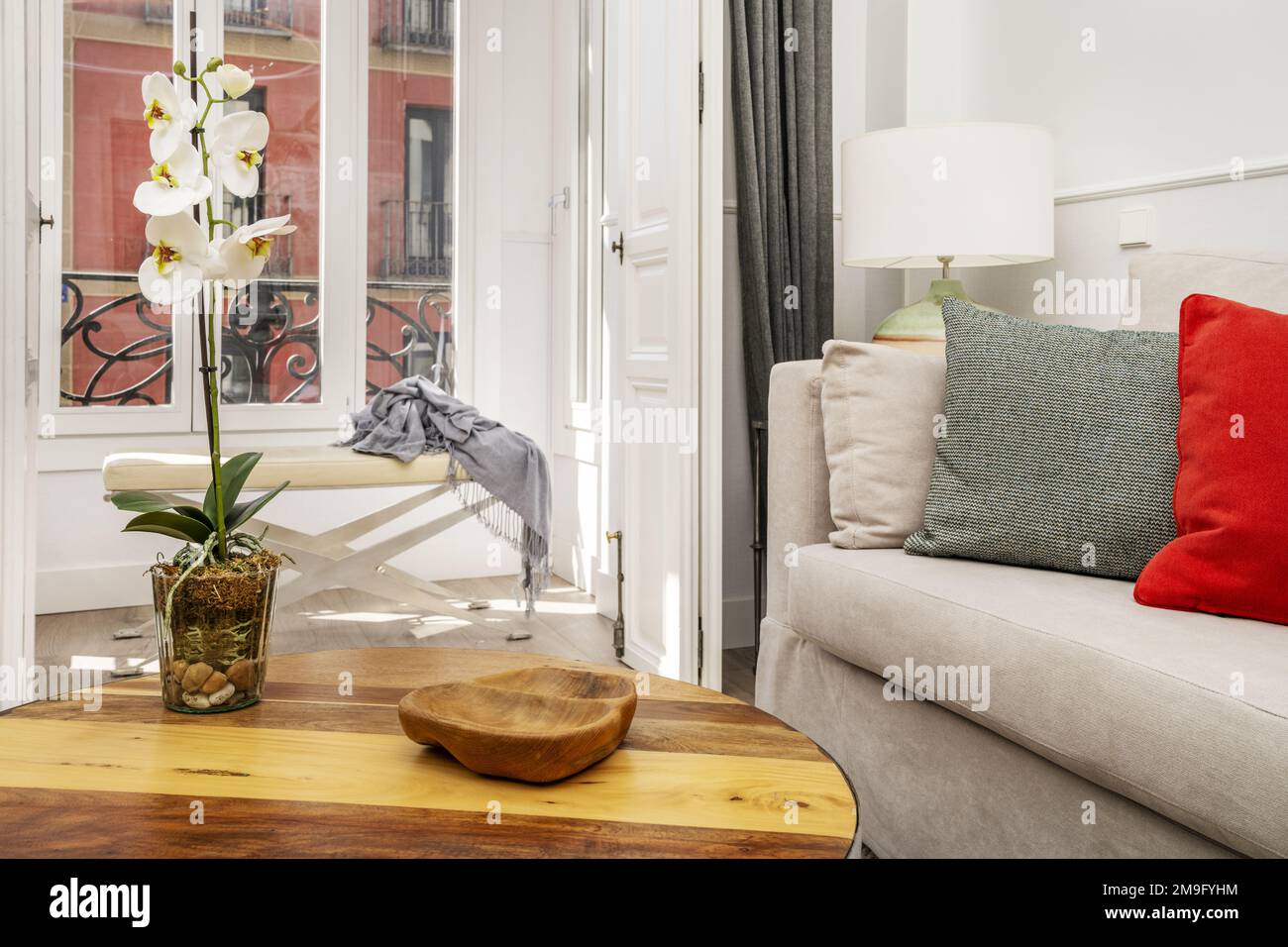 Corner of a living room with decorative objects on a round wooden table ...
