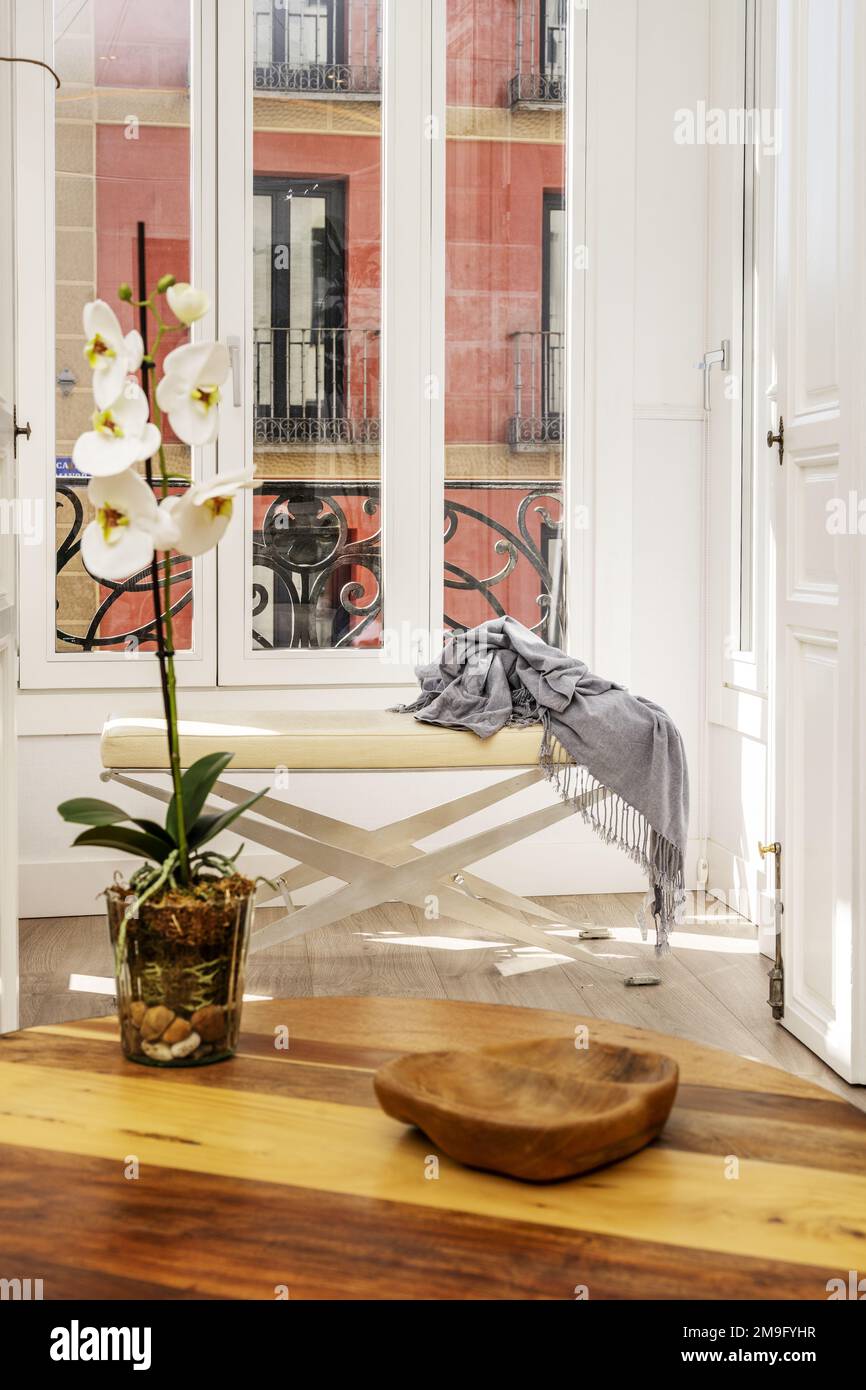 Corner of a living room with decorative objects on a round wooden table ...