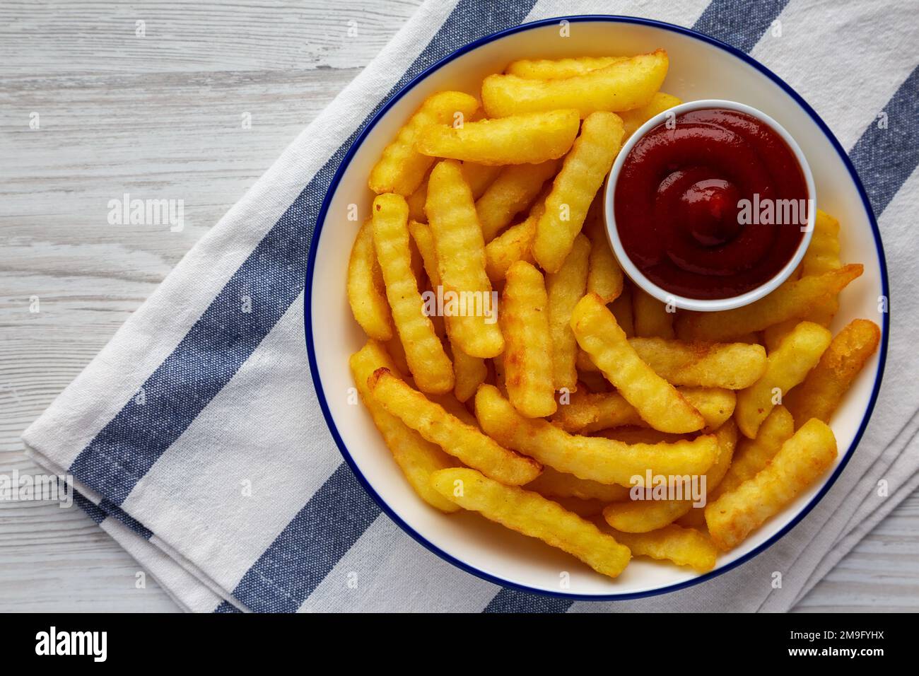 Homemade Unhealthy Crinkle French Fries with Ketchup on a Plate, top ...