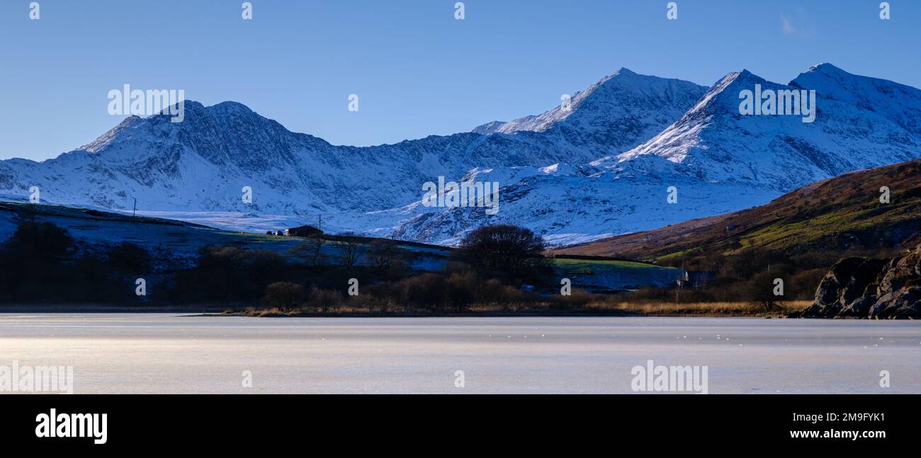 Panoramic view of the Snowdon Horseshoe mountains with a frozen lake in ...