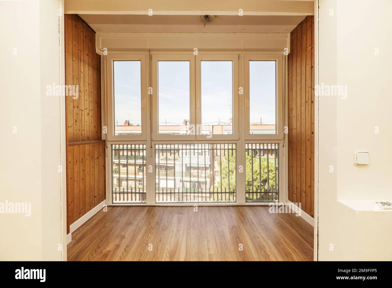 Closed terrace with white aluminum glazing and walls covered with ...