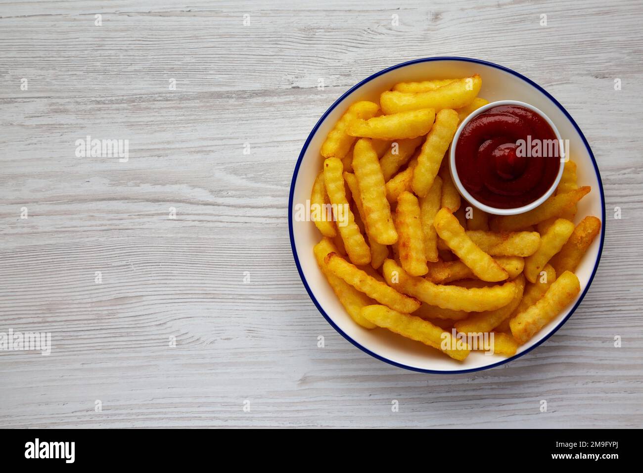 Homemade Unhealthy Crinkle French Fries with Ketchup on a Plate, top ...