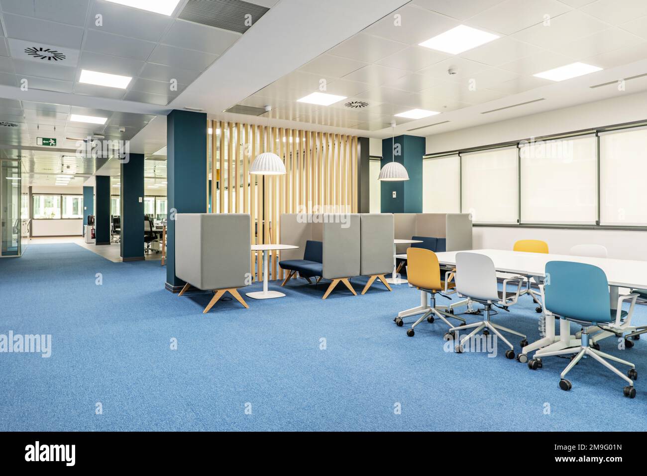 A coworking office with a boardroom table and meeting booths, wooden ...