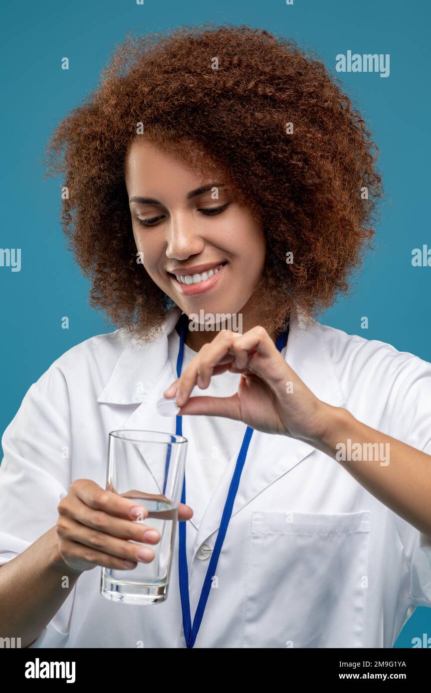 Doctor putting effervescent pills into water Stock Photo - Alamy