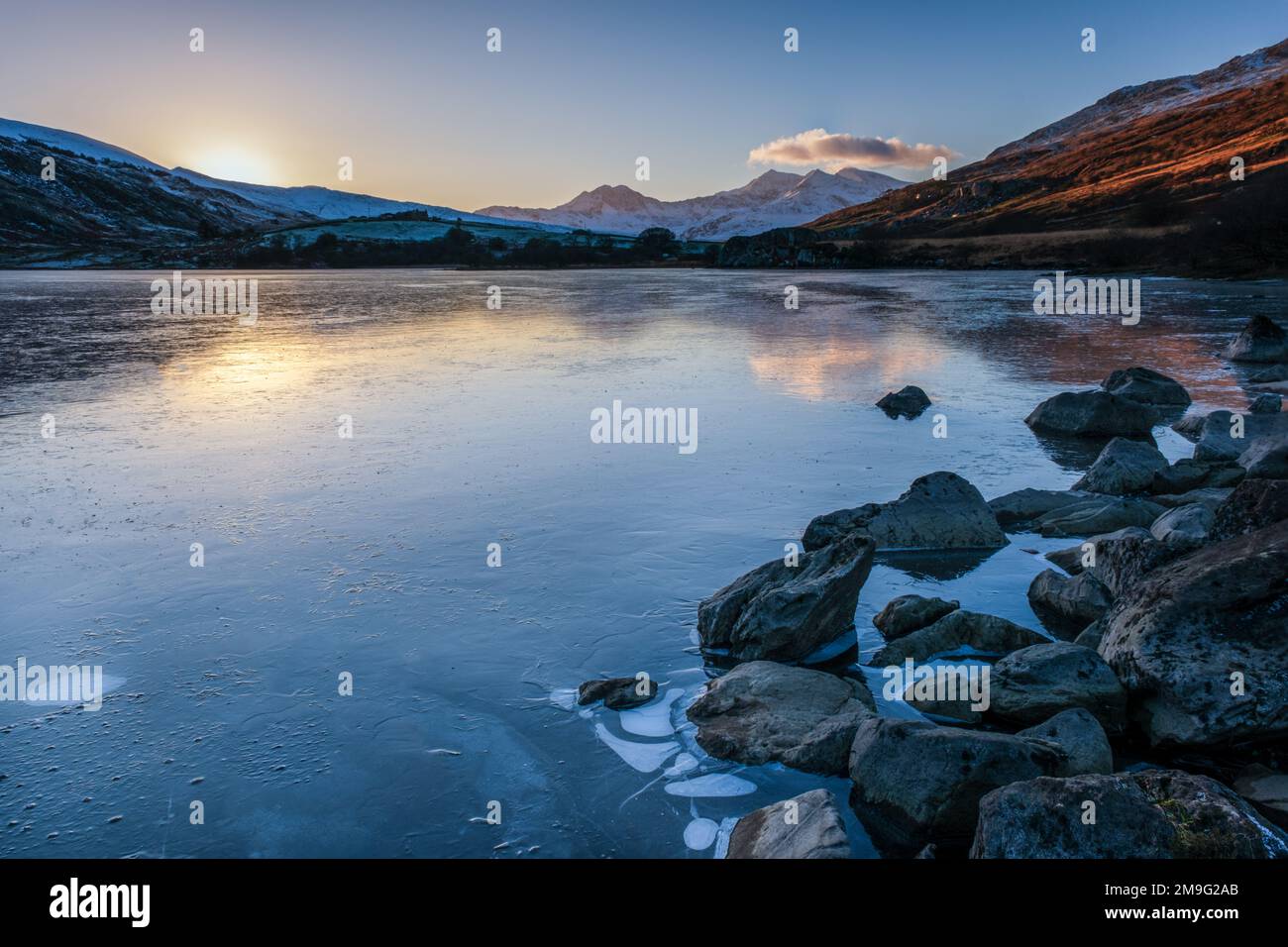 A view of the Snowdon Horseshoe mountains with a frozen lake in the ...