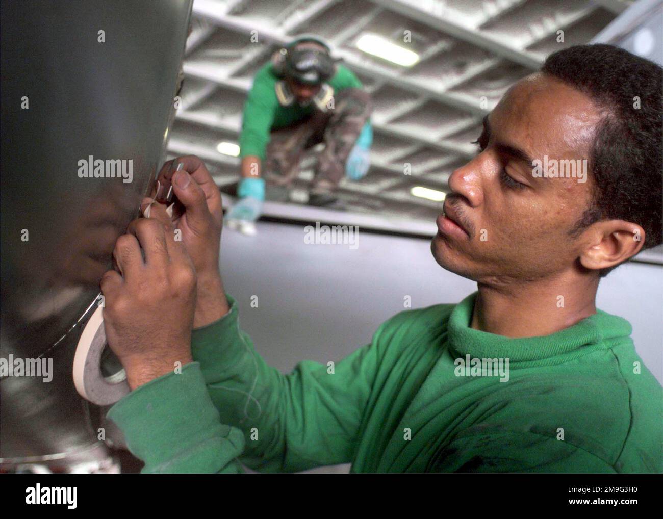 US Navy Aviation Structural Mechanic Meron Msgna tapes the body of an F ...