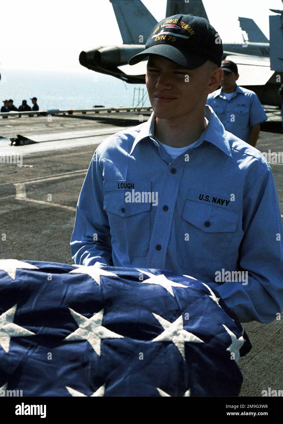 US Navy AIRMAN Keith Lough prepares to raise the Stars and Stripes as ...