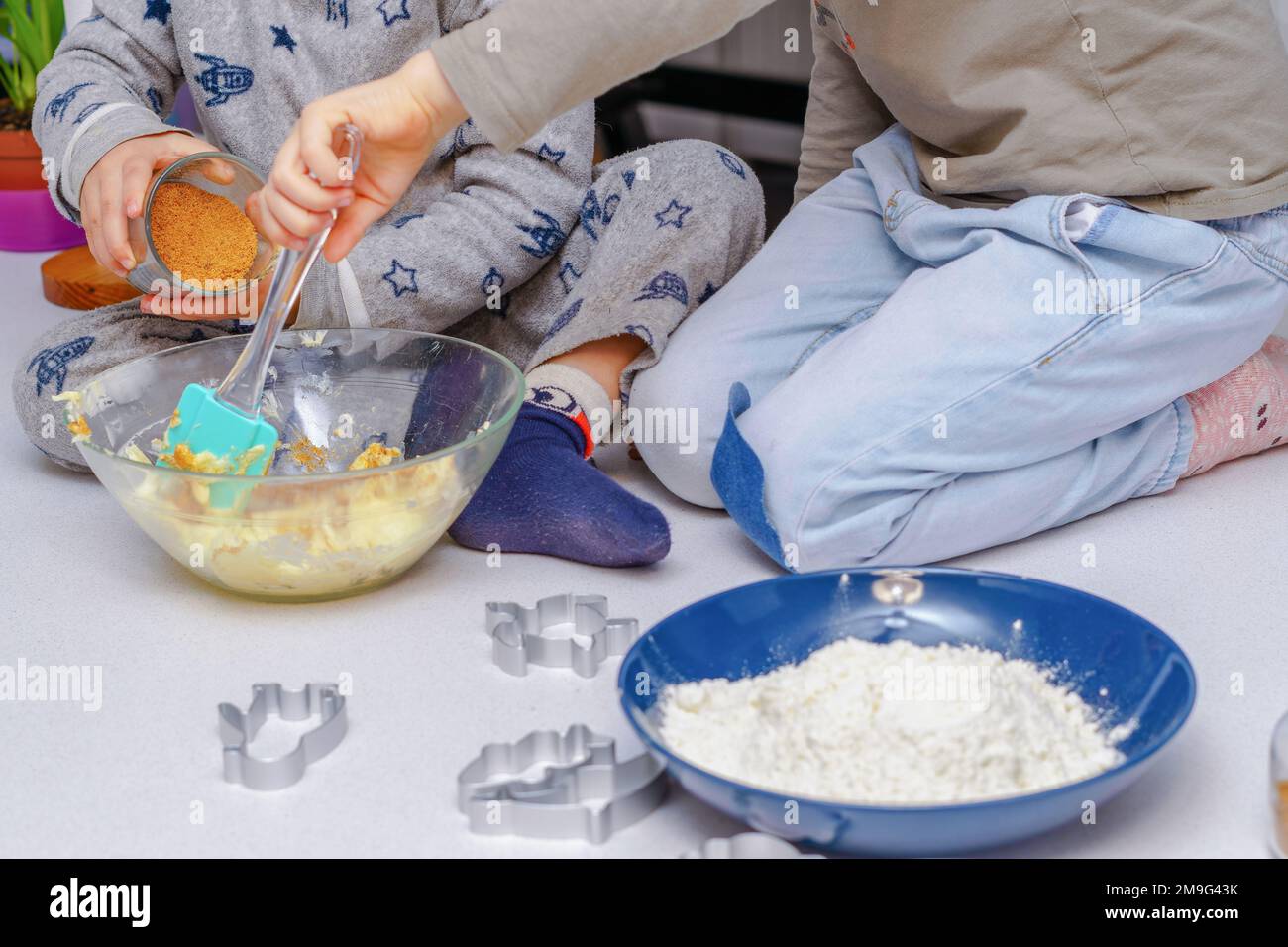 children on a table mixing the ingredients to prepare a cake Stock ...