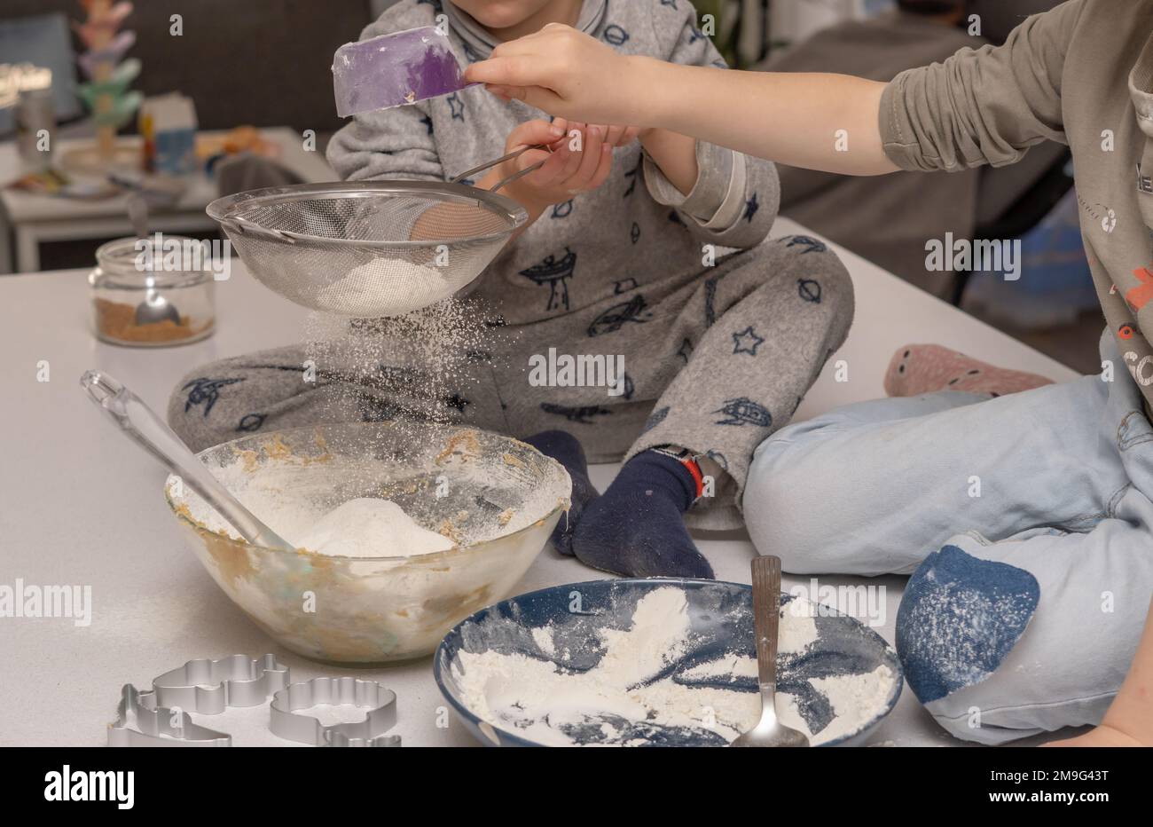 children adding flour to a large sieve for a cake mixture Stock Photo ...