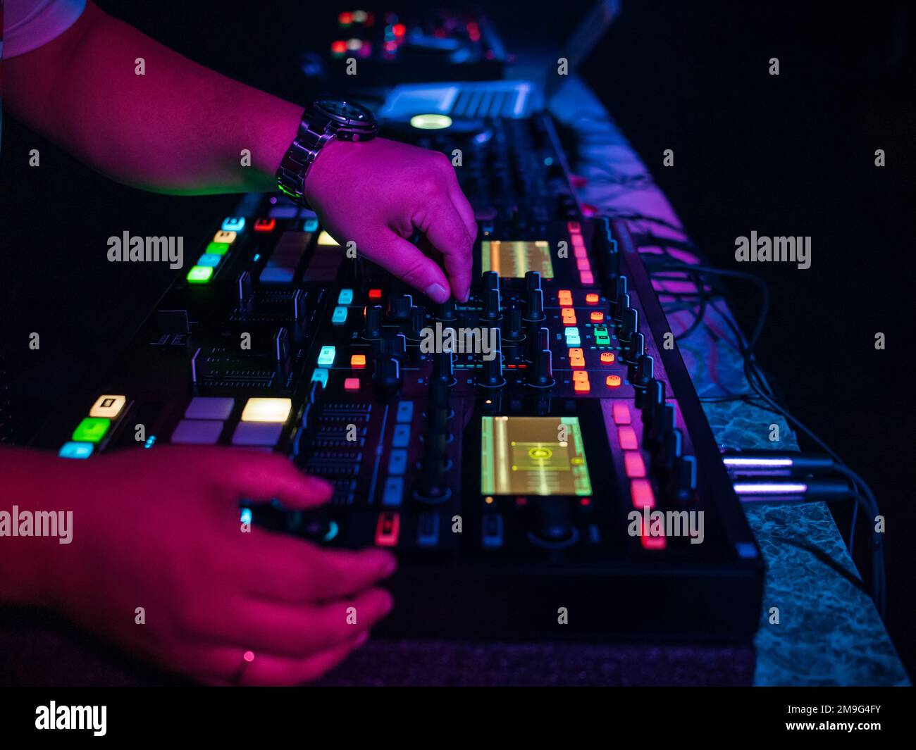 hands DJ mixing and playing music on a professional controller mixer ...