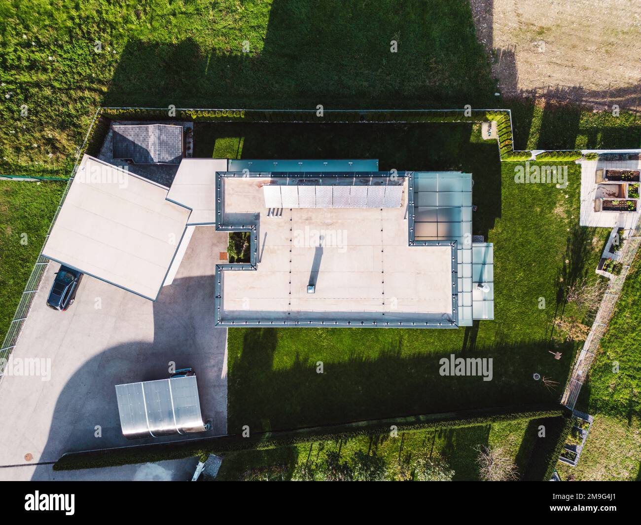 Top down view at the lot of a modern family home with flat rooftop and ...