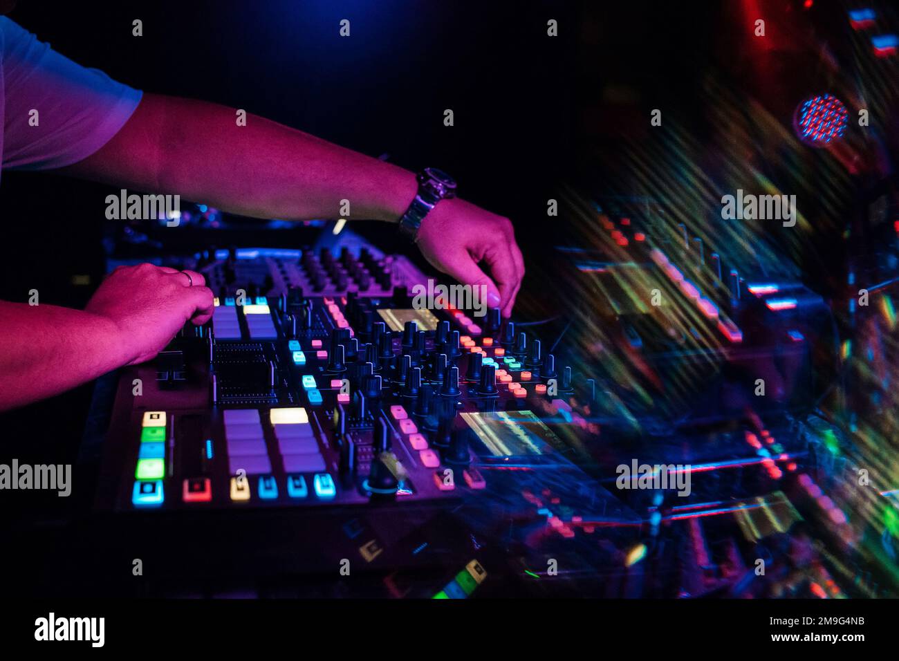 hands DJ mixing and playing music on a professional controller mixer ...