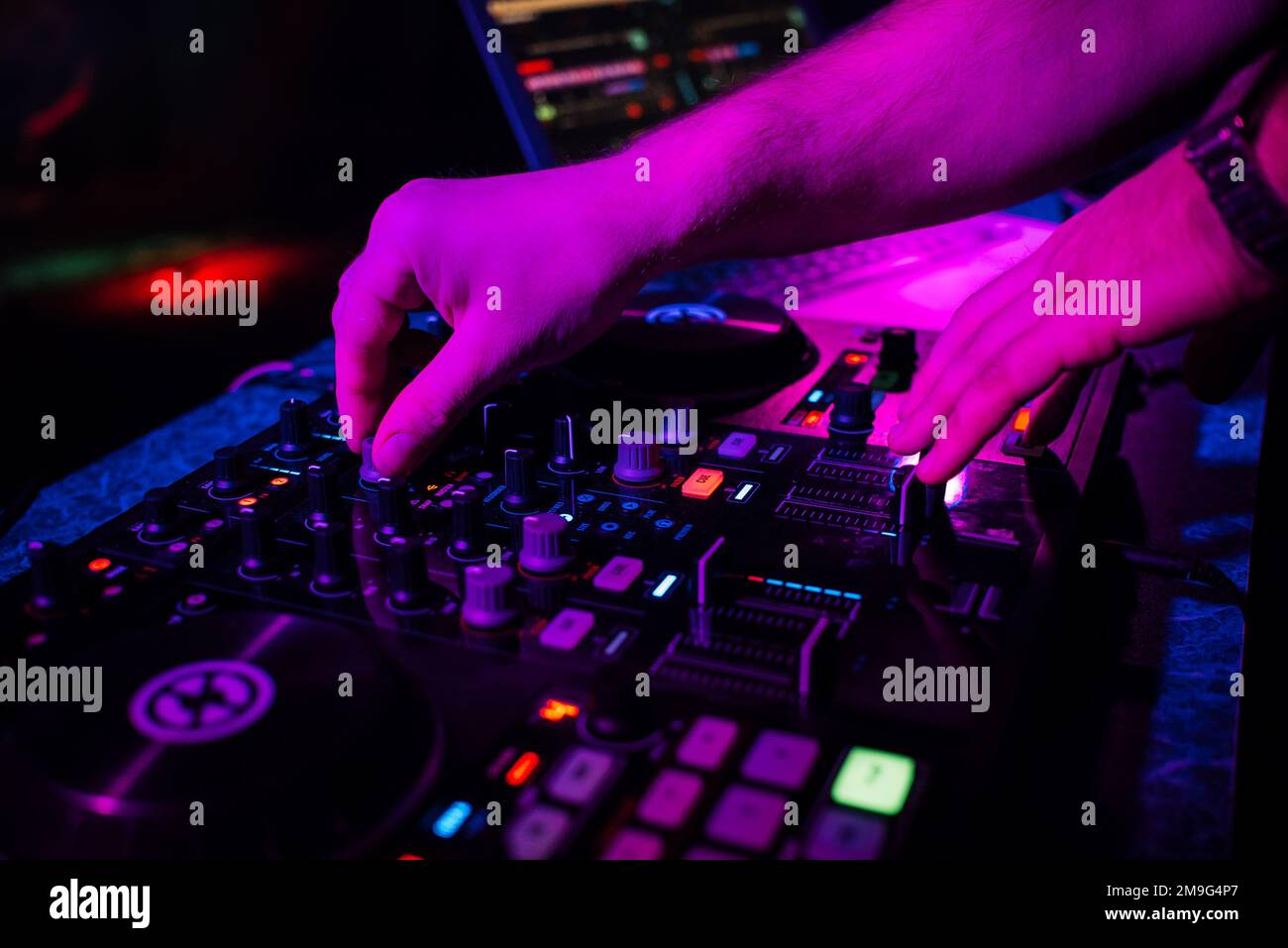 hands DJ playing and mixing music on a modern music controller at a ...