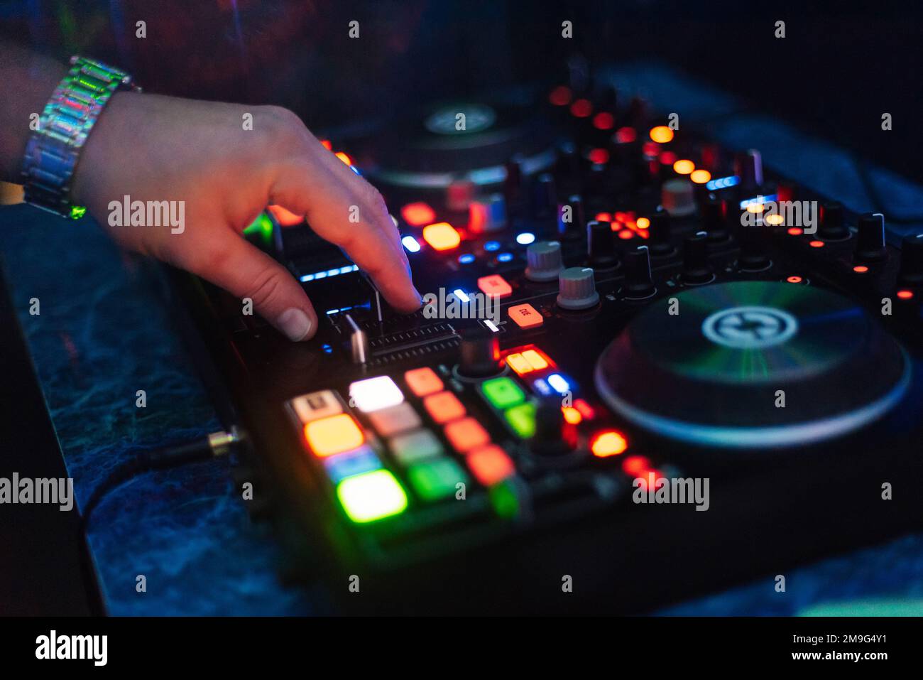 hands DJ playing and mixing music on a modern music controller at a ...
