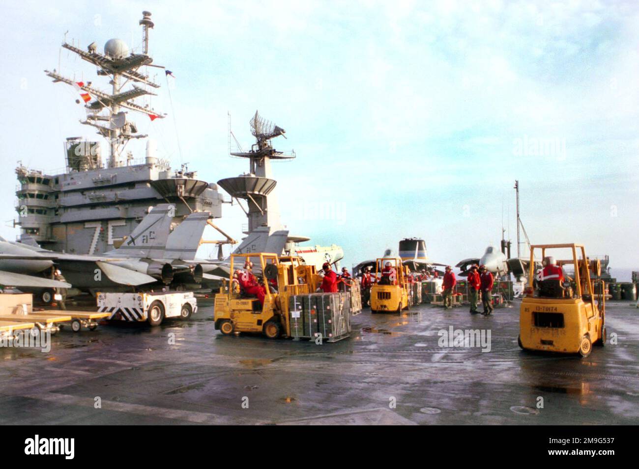US Navy Aviation Ordnancemen spot ordnance containers for transfer to ...