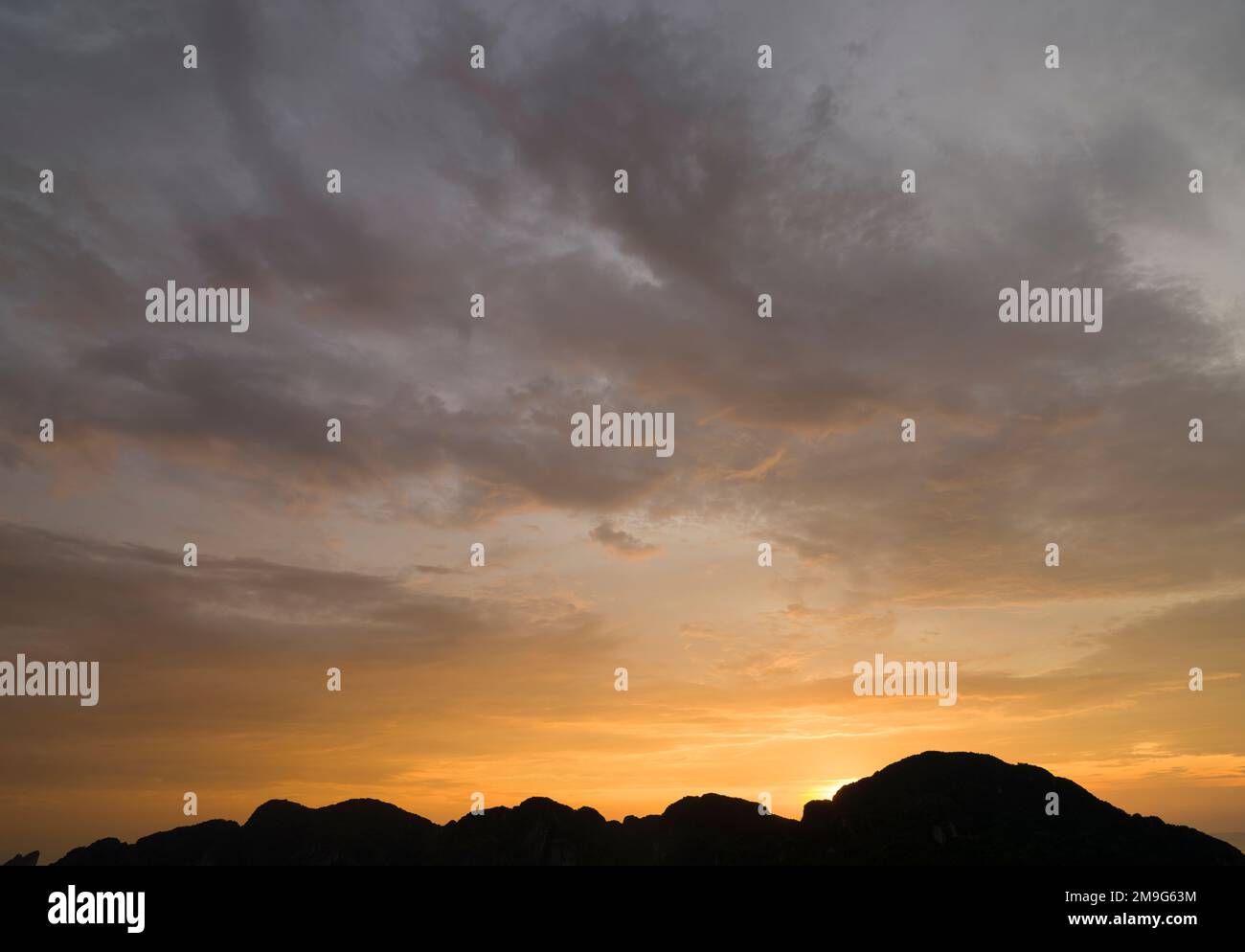hills followed by setting sun and dramatic sky Stock Photo - Alamy