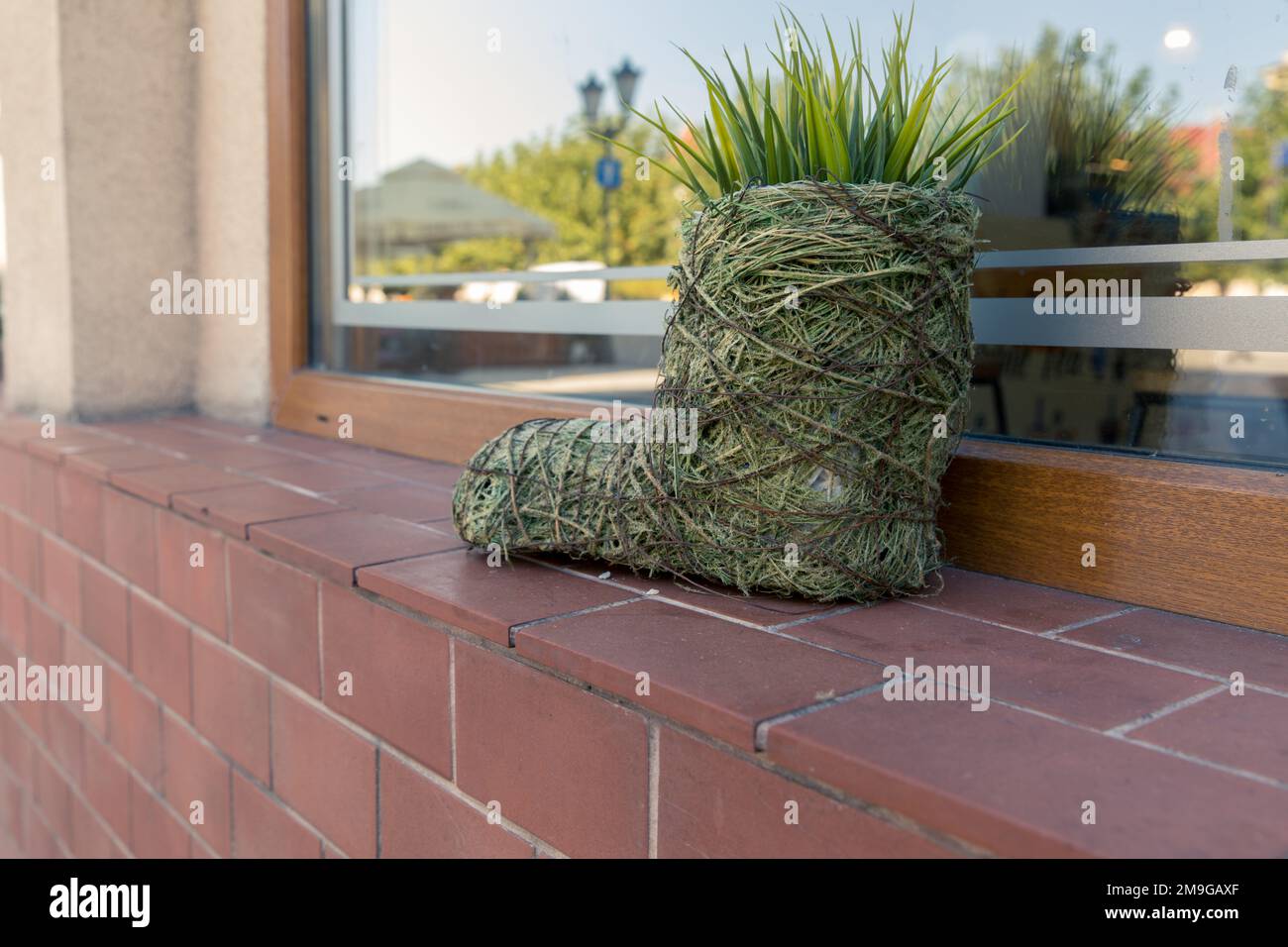 Grass growing from a shoe made of hay, an ornament on the window sill ...