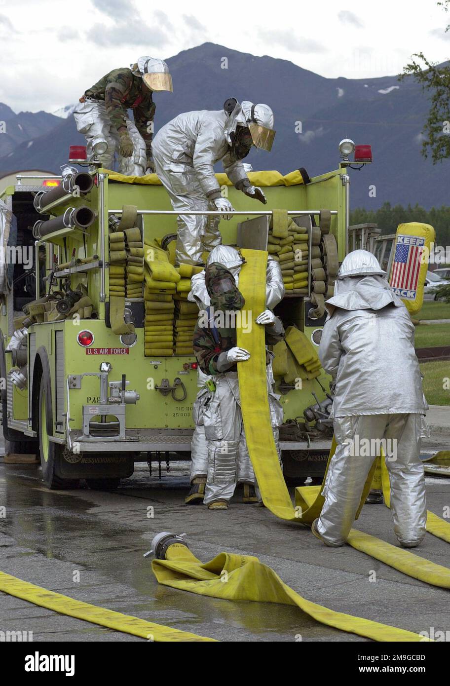 Firemen from the 3rd Civil Engineering Squadron, Elmendorf AFB, re-roll ...