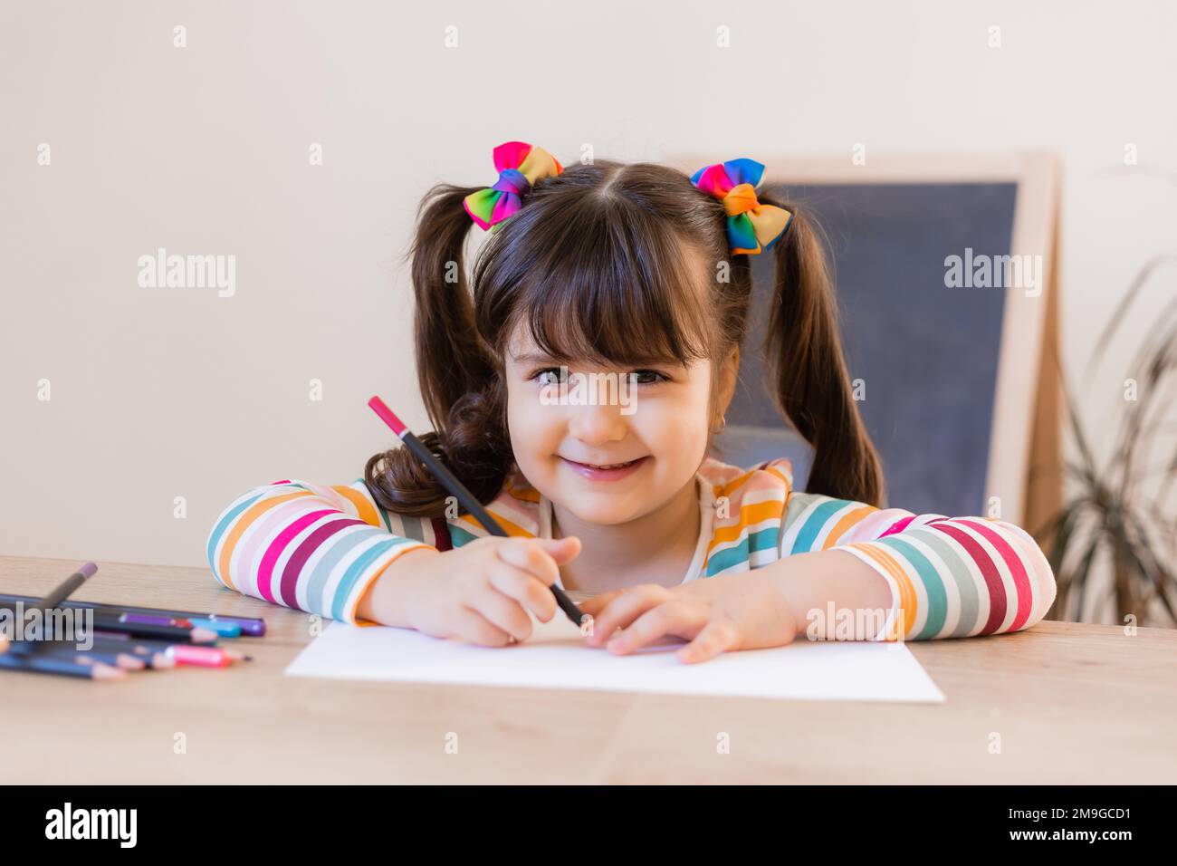 cute little girl draws with colored pencils Stock Photo - Alamy