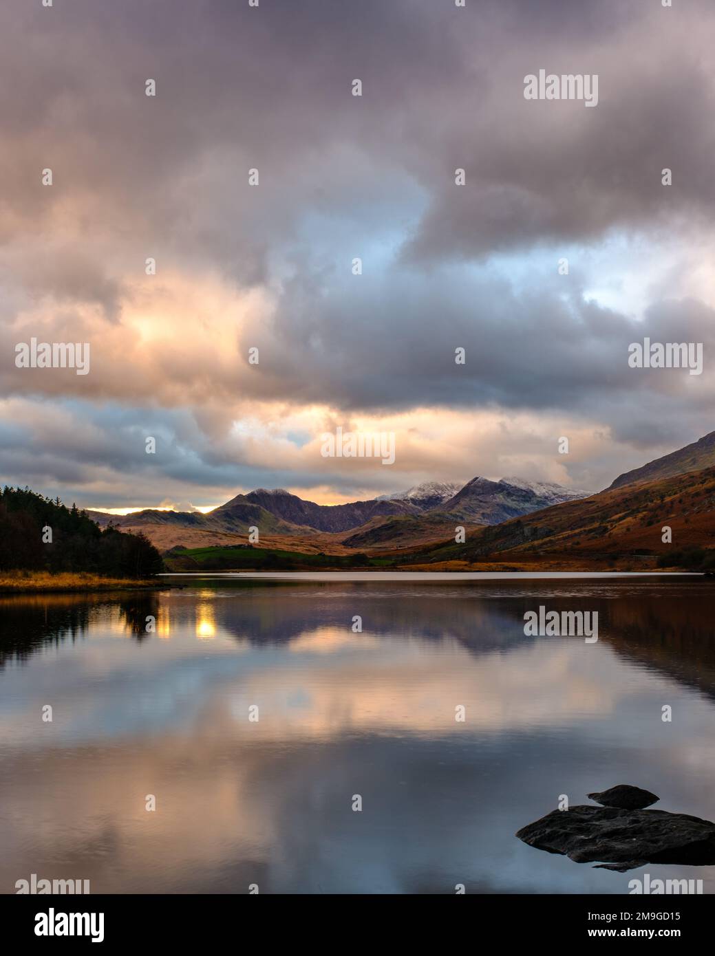 Perfect reflection of snow covered Snowdon Horseshoe mountains in a lake in Snowdonia National ...