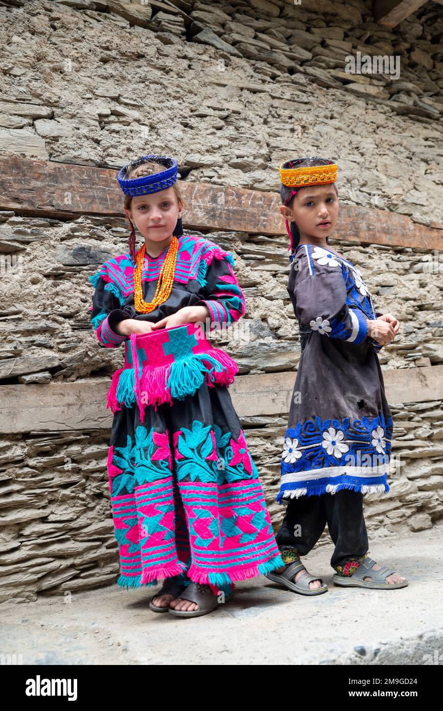Two young girls wearing traditional attire on the street of a Kalash ...