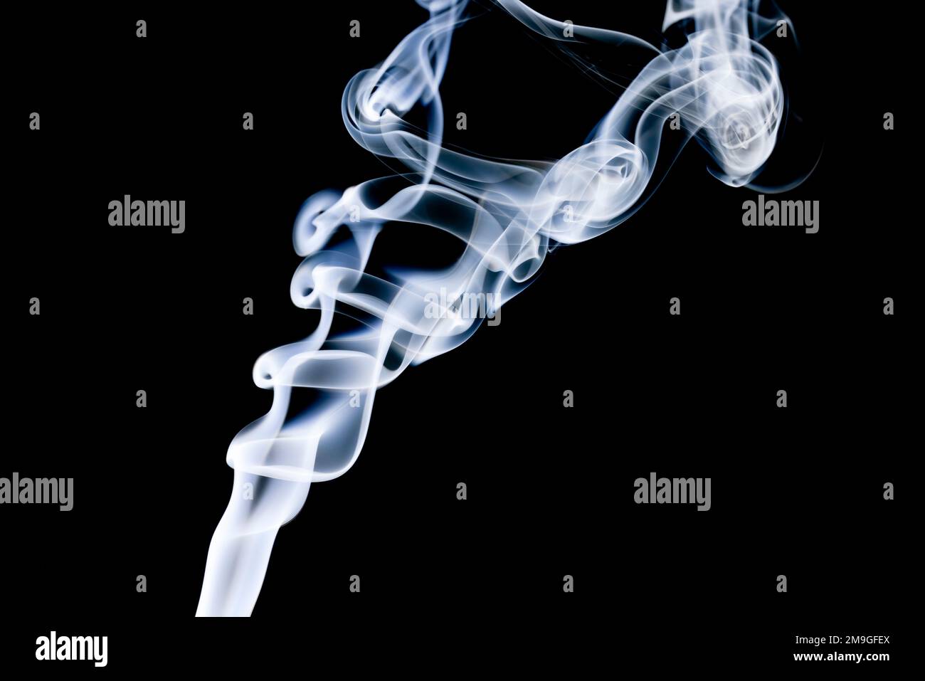 Artistic looking smoke swirls photographed against a plain black ...