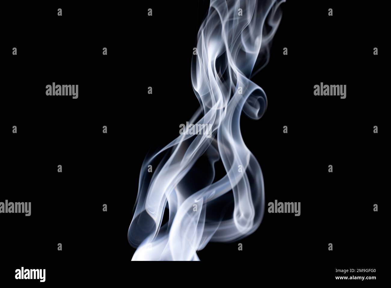 Artistic looking smoke swirls photographed against a plain black ...