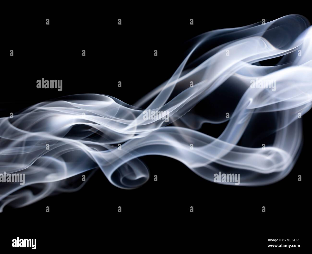 Artistic looking smoke swirls photographed against a plain black ...