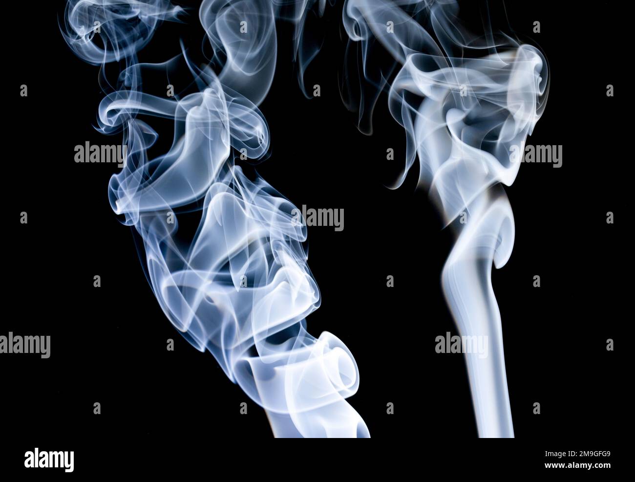Artistic looking smoke swirls photographed against a plain black ...