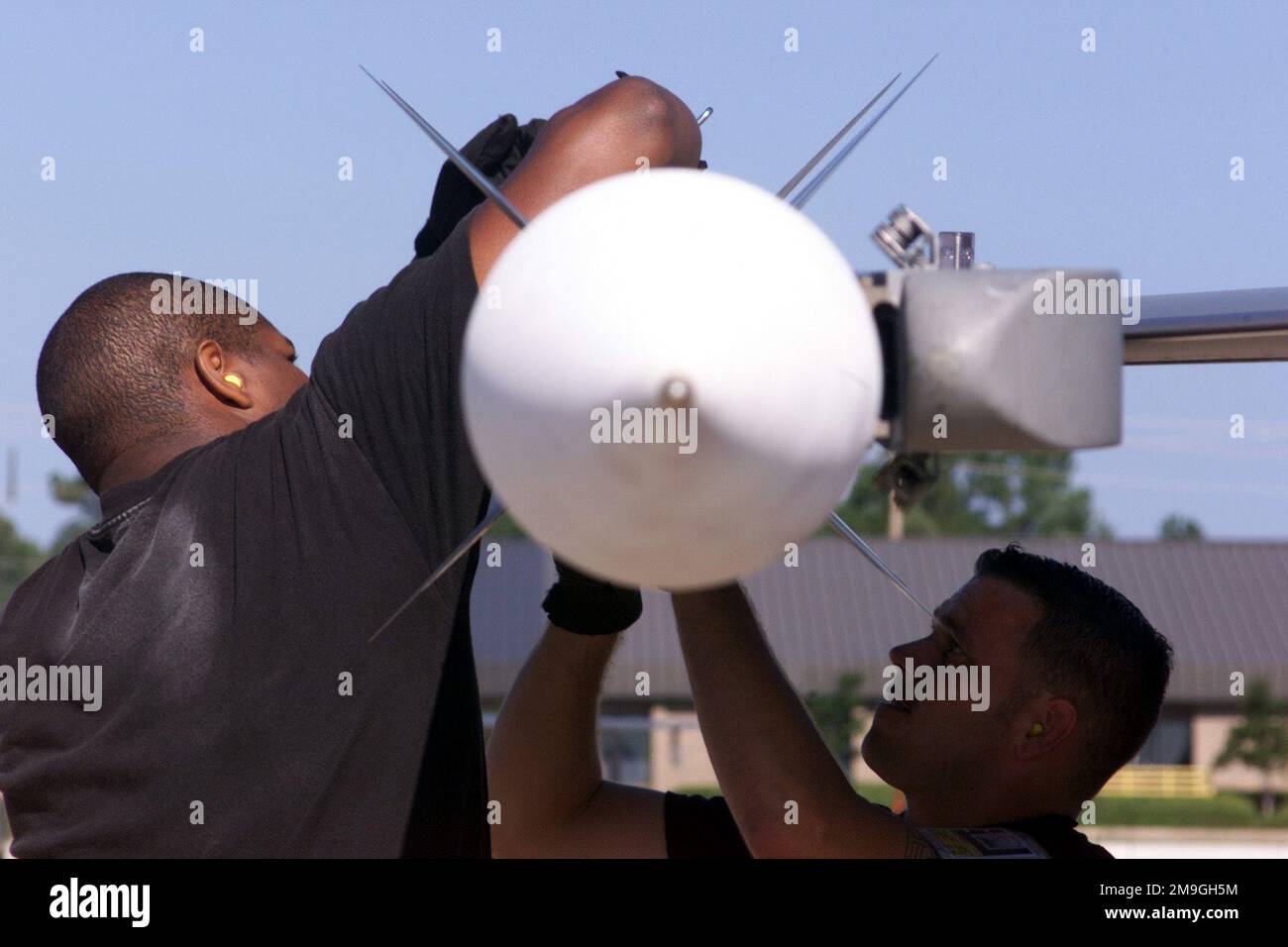 USAF personnel attach the flight control fins to an AIM-120 Advanced ...