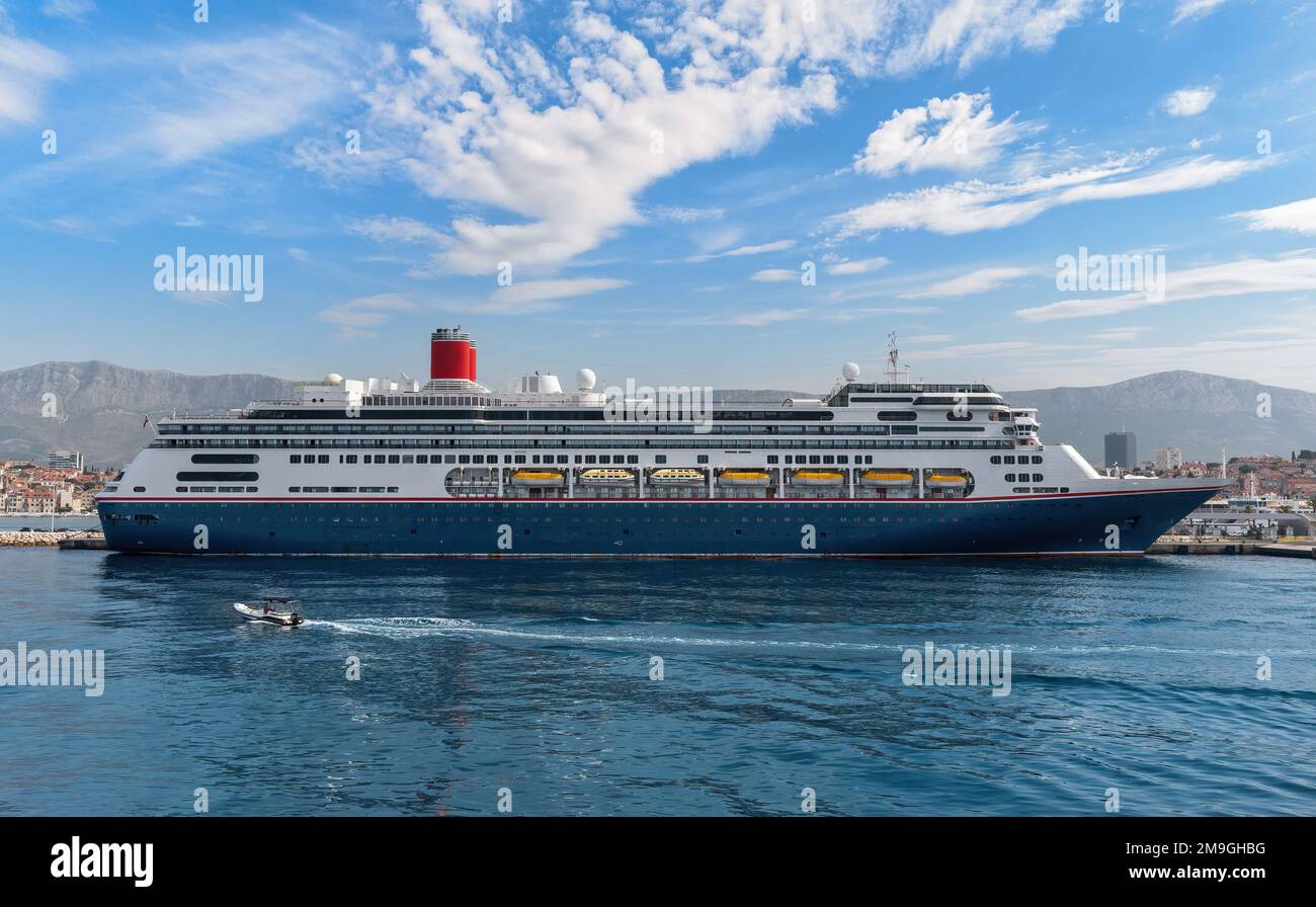 A large and luxurious cruise ship docked in the magnificent waters of ...