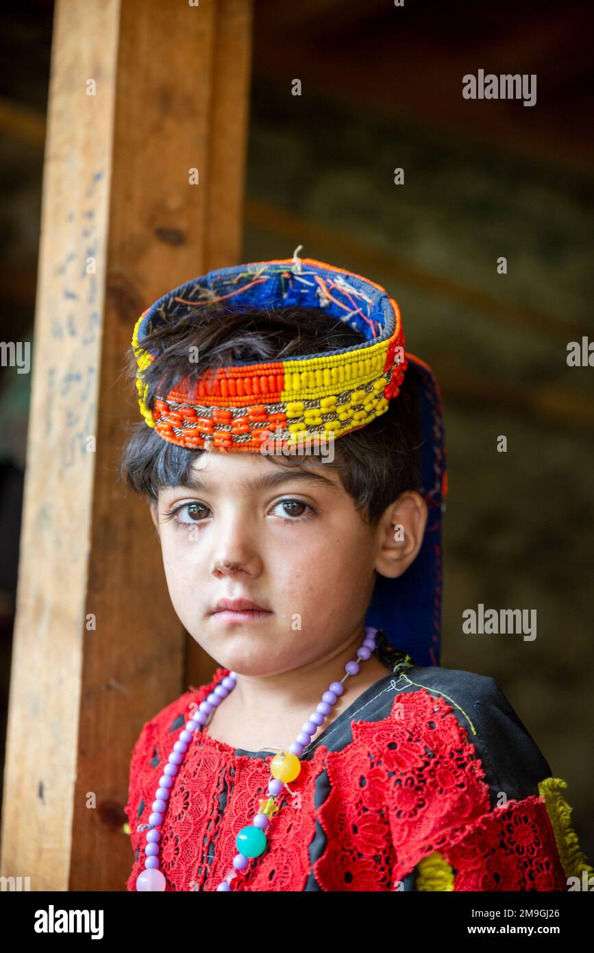 Portrait of a young Kalash girl with traditional beaded headdress ...