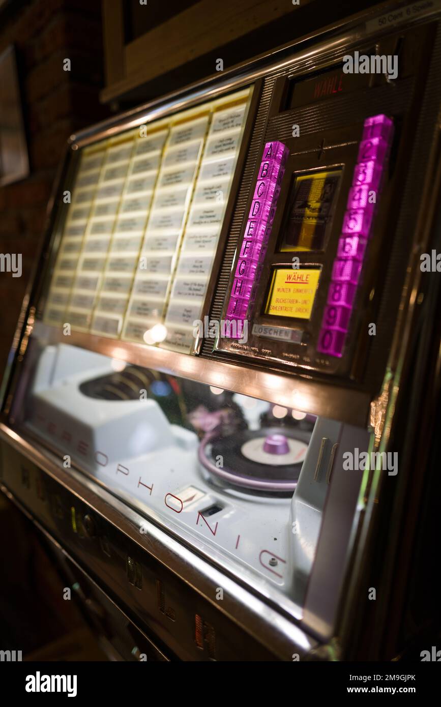 A Jukebox with songs on vinyls. a front with available songs and the ...