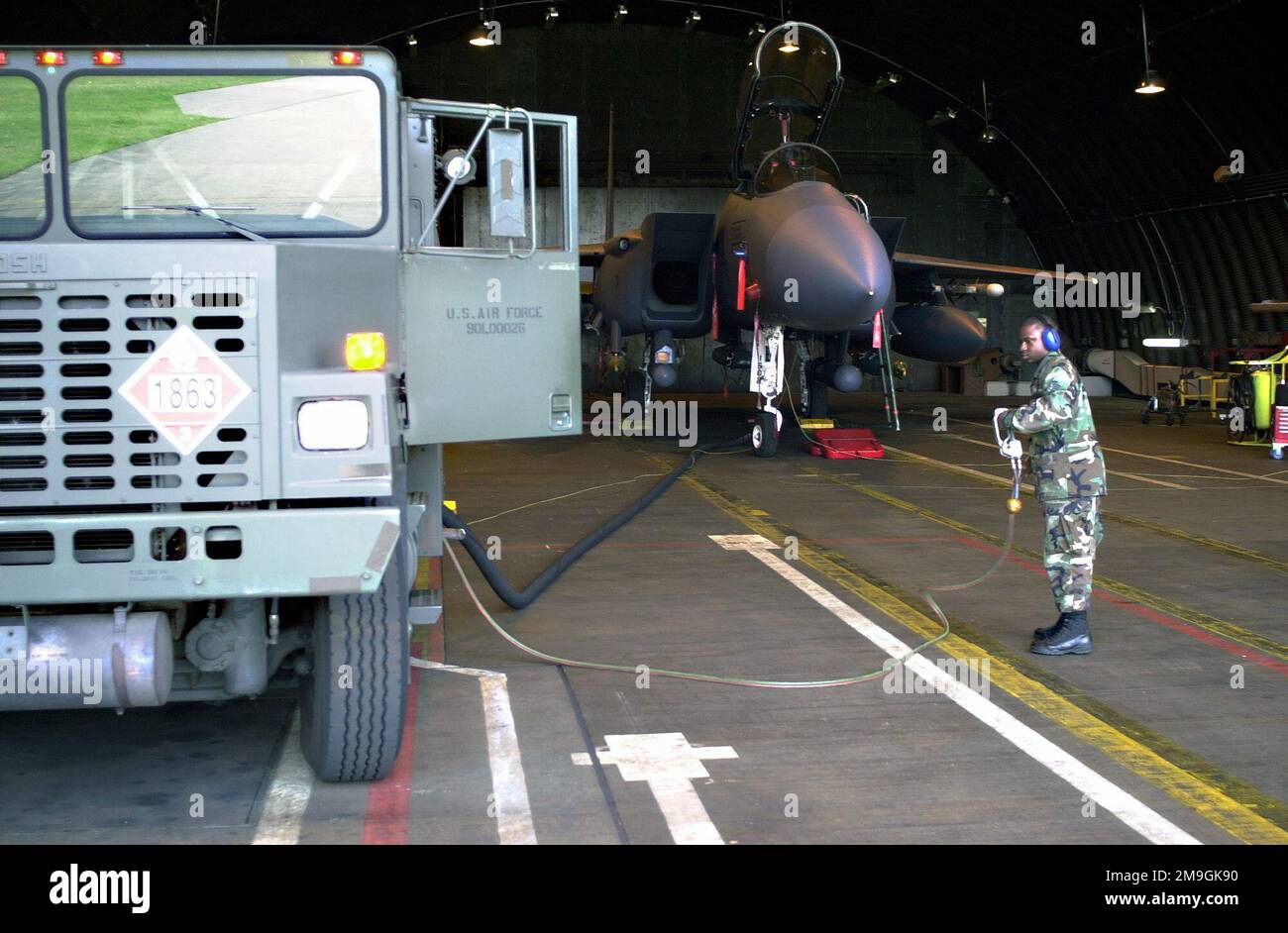 Parked inside a hardened shelter, an F-15E Strike Eagle is refueled by ...