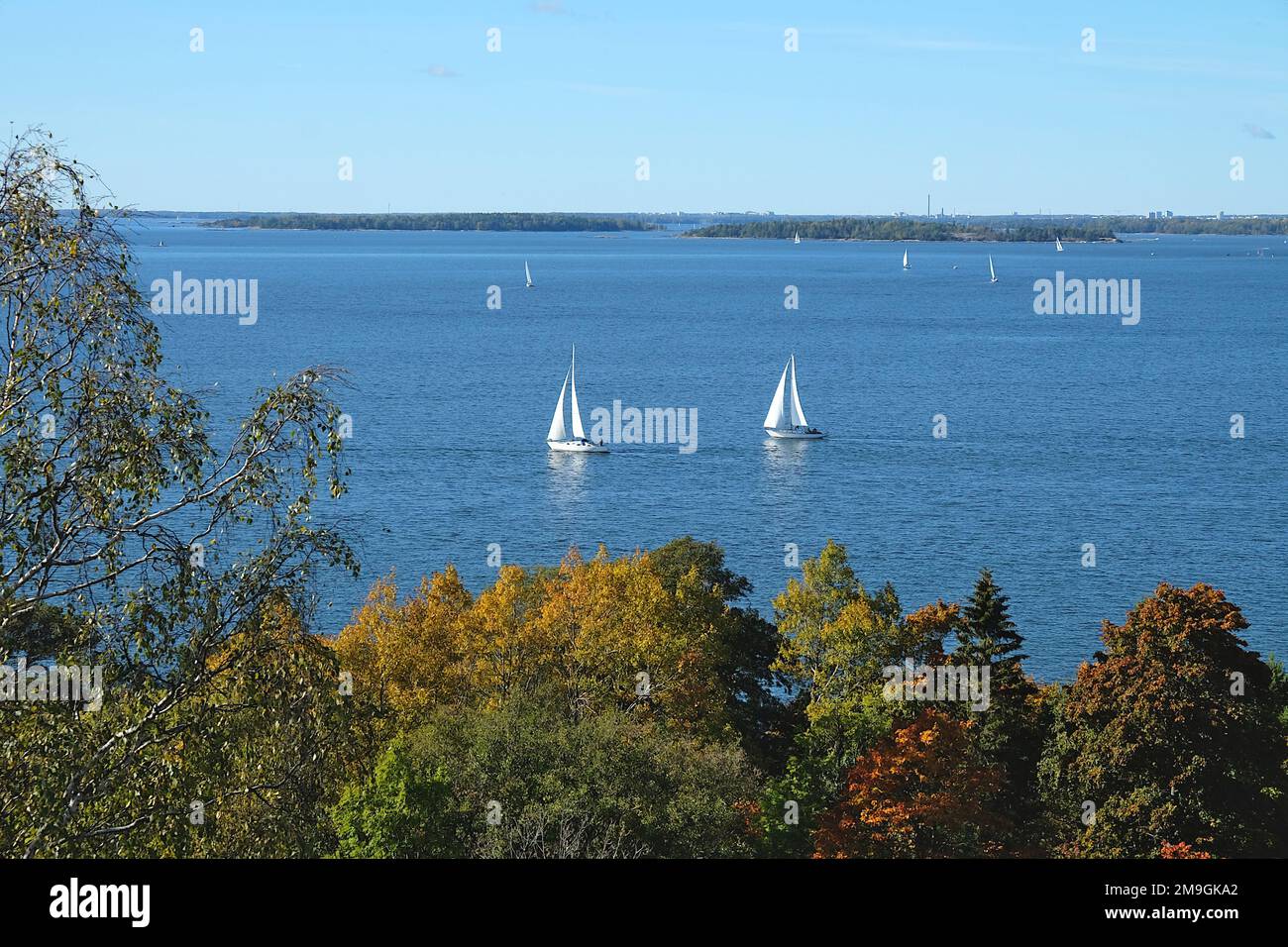 View over the strait between two islands with autumn colored trees ...