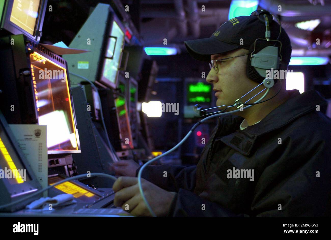 A US Navy Operations SPECIALIST works on the Strike Control Console ...