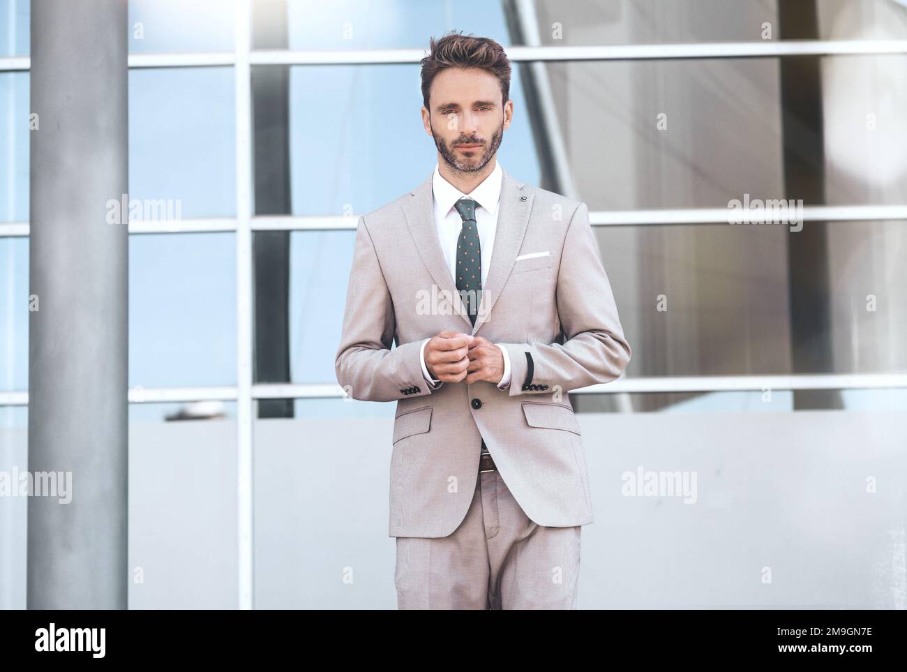 Handsome man model standing by the office building wearing a silver ...