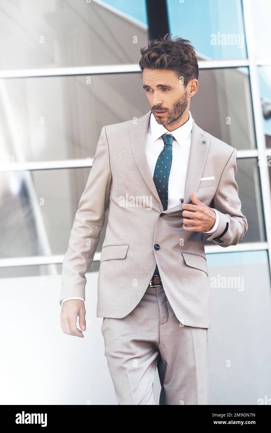 Handsome man model standing by the office building wearing a silver ...