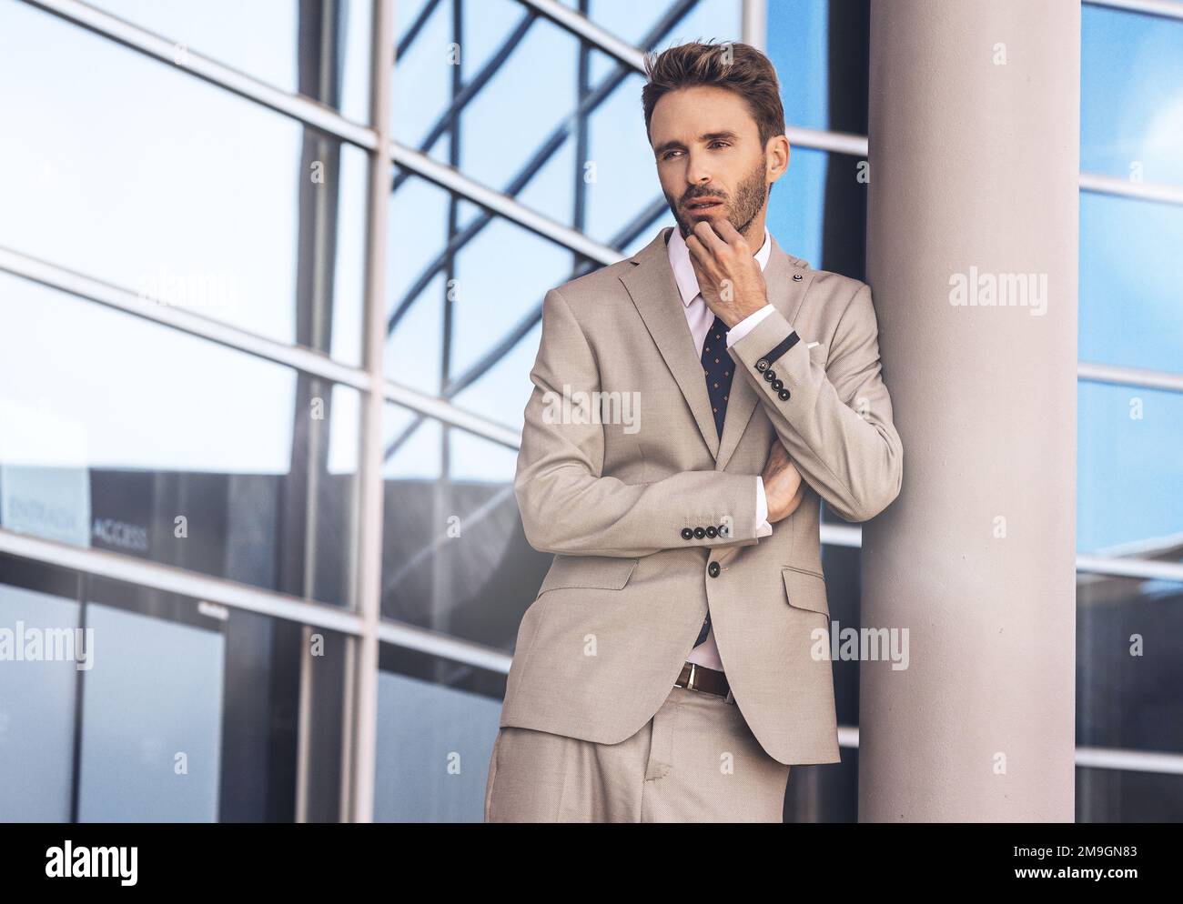 Handsome man model standing by the office building wearing a silver ...