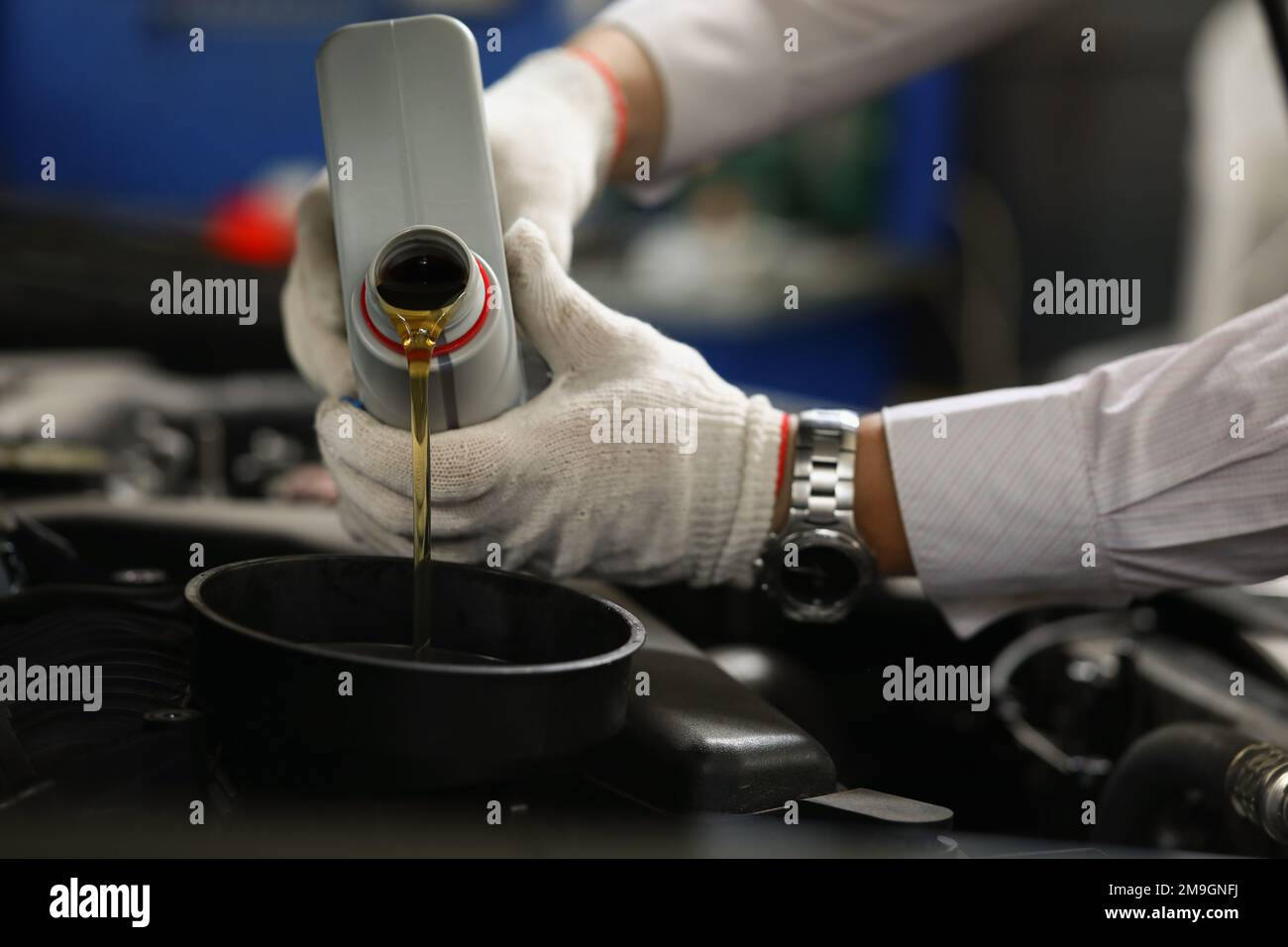 Hands of mechanic pours oil into car engine Stock Photo - Alamy