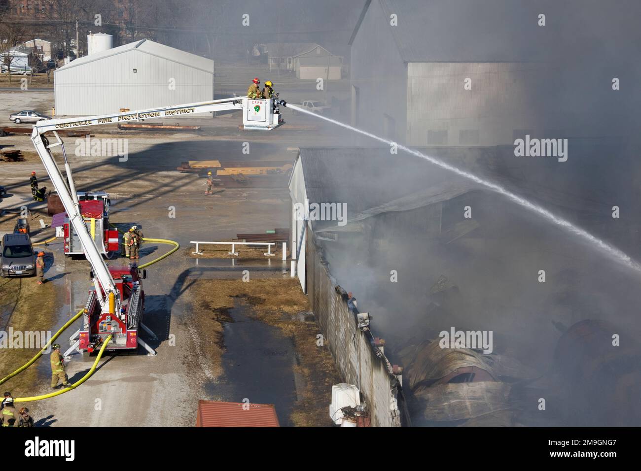 63818-02315Firefighters extinguishing warehouse fire using aerial ...