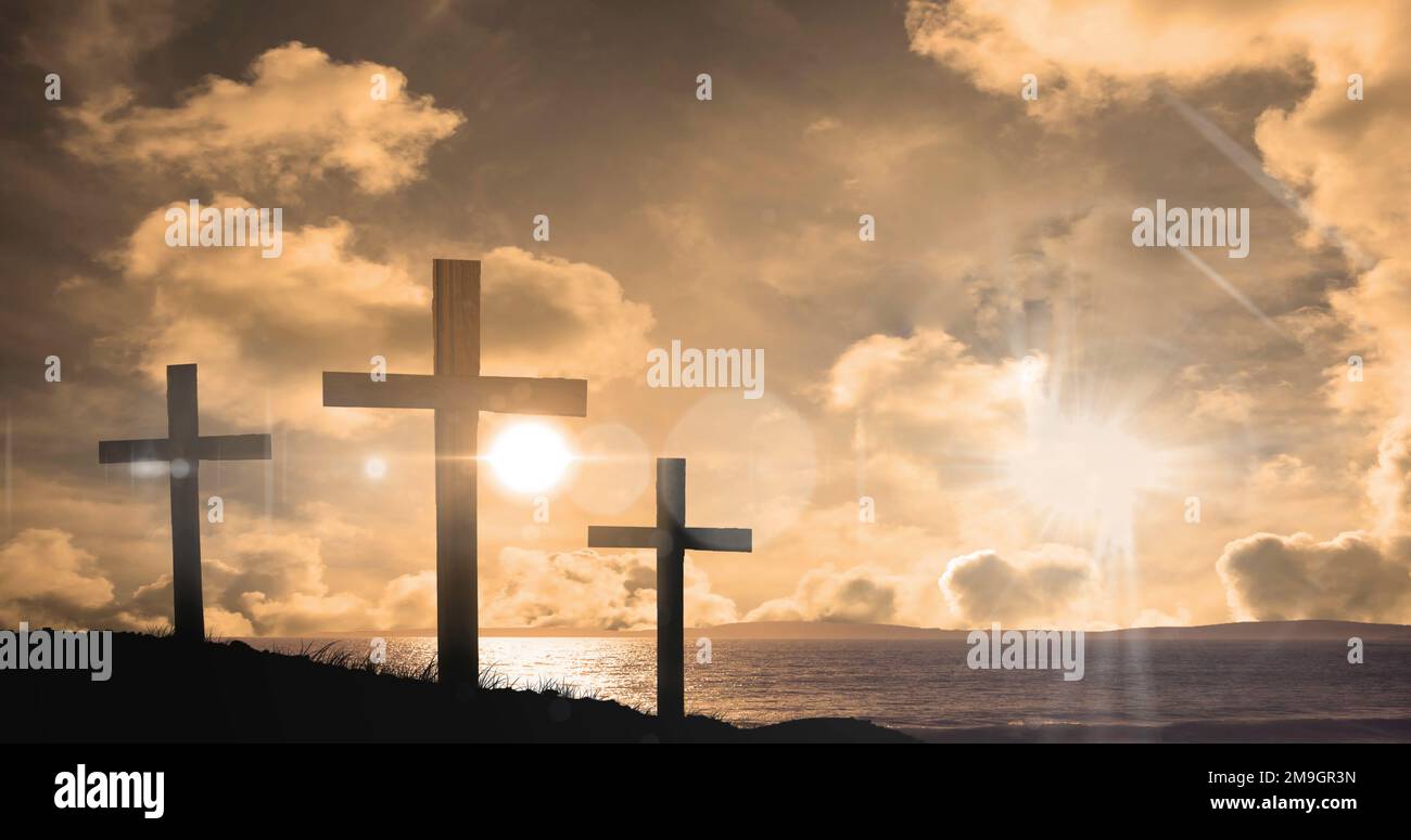 Image of three christian crosses over landscape with sun glowing on ...