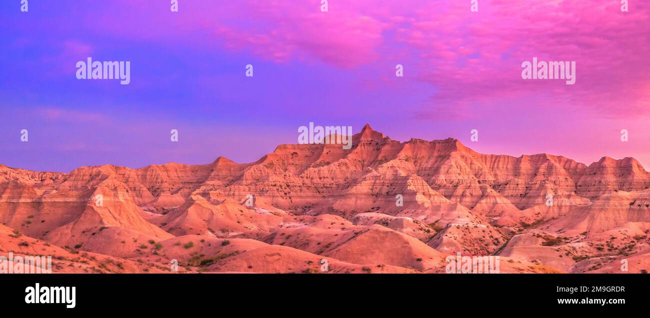 panorama of a colorful sunrise over the yellow mounds area of badlands ...