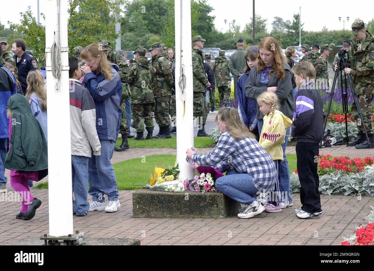Placing flower at the base of the American flag, flown at half-mast ...