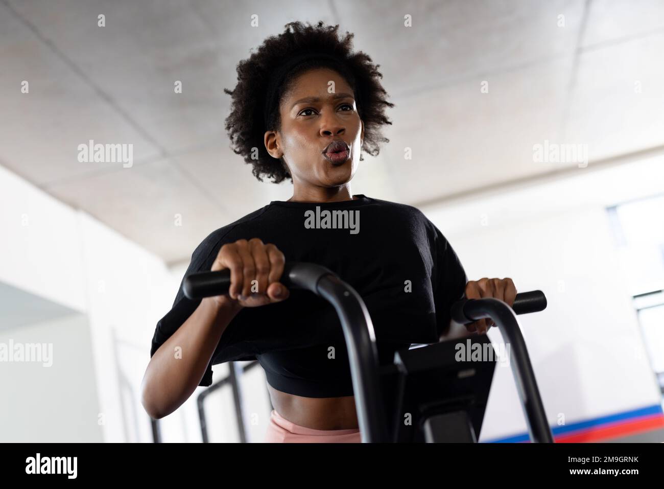 African american fit woman exercising and using cross trainer at gym ...